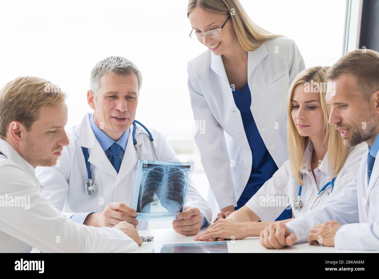 Team of experts doctors examining X-ray report on hospital office ...