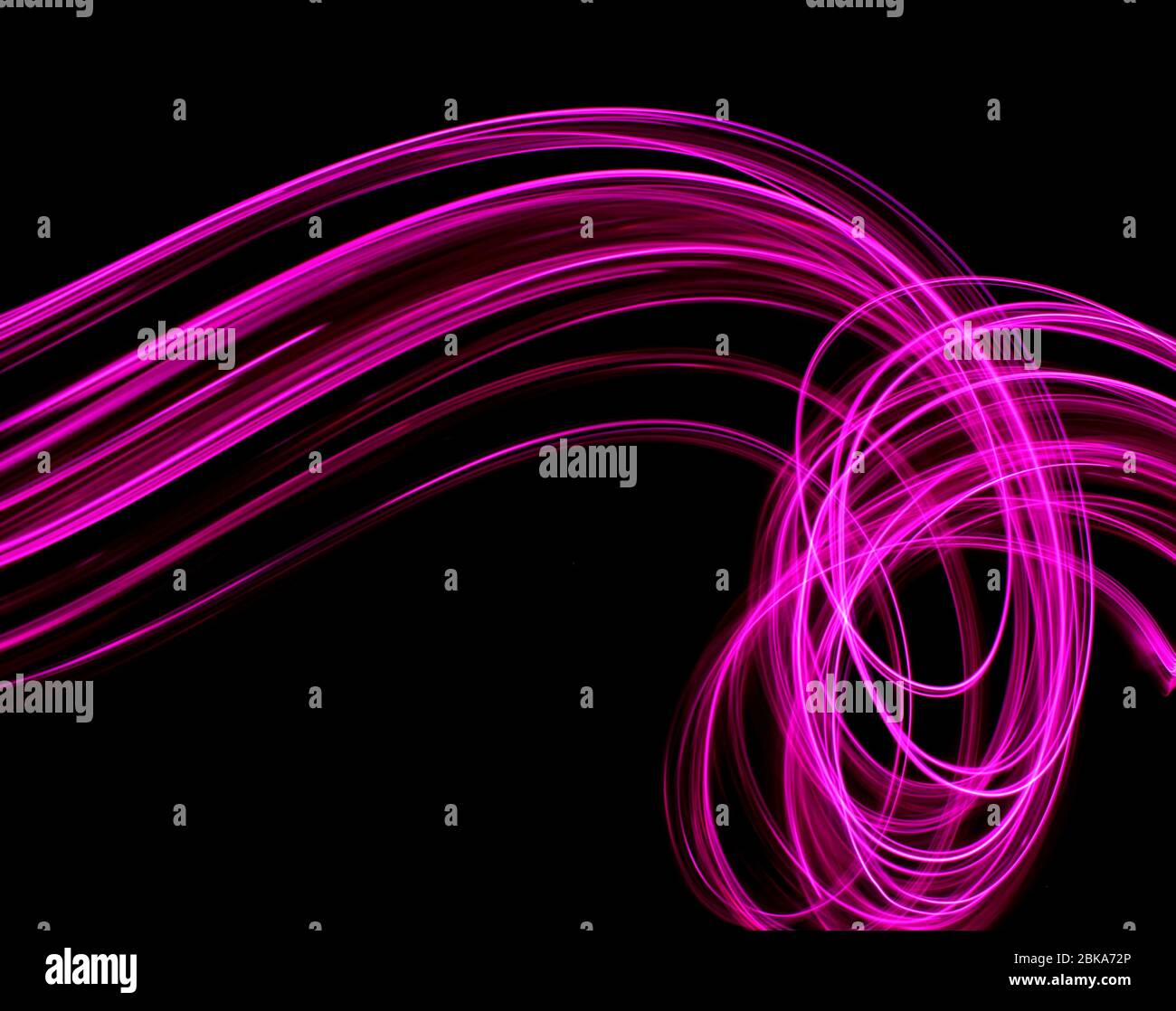 Long exposure photograph of neon pink colour in an abstract swirl ...