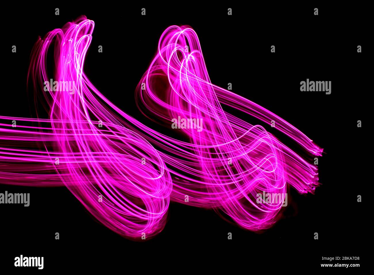 Long exposure photograph of neon pink colour in an abstract swirl ...