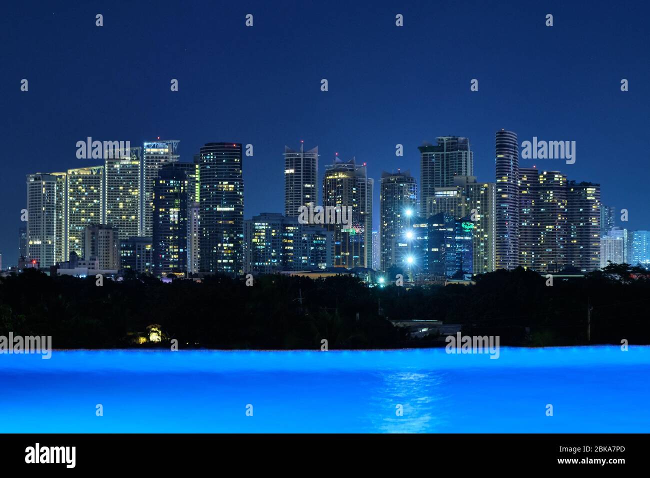 View of the night city of Manila from the pool of the luxury five-star ...