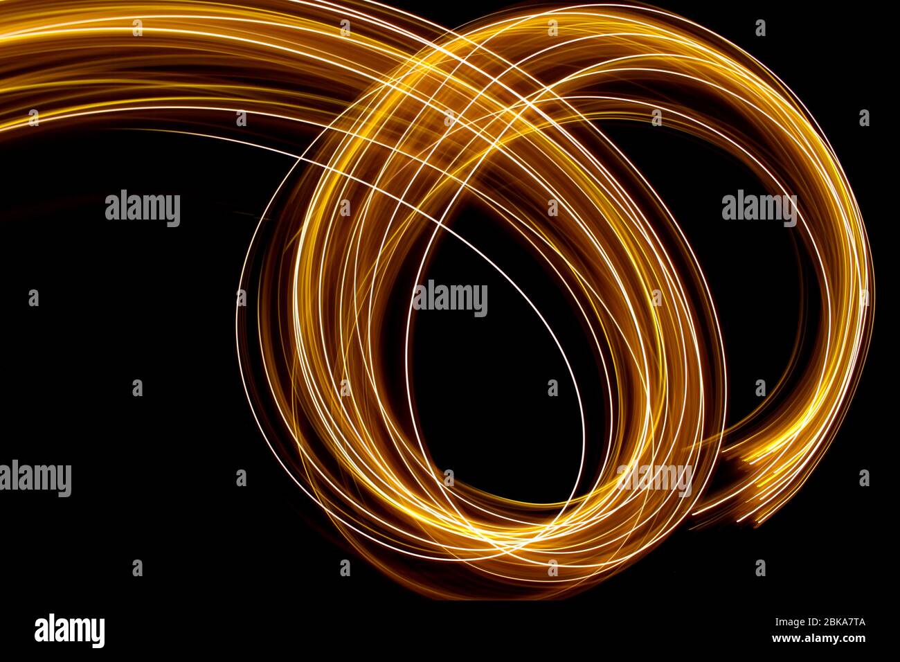 Long exposure photograph of neon gold colour in an abstract swirl ...