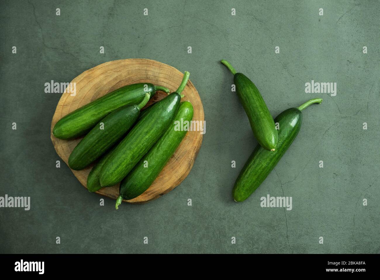 Organic mini cucumber on wooden serving plate ready to eat. Freshly ...