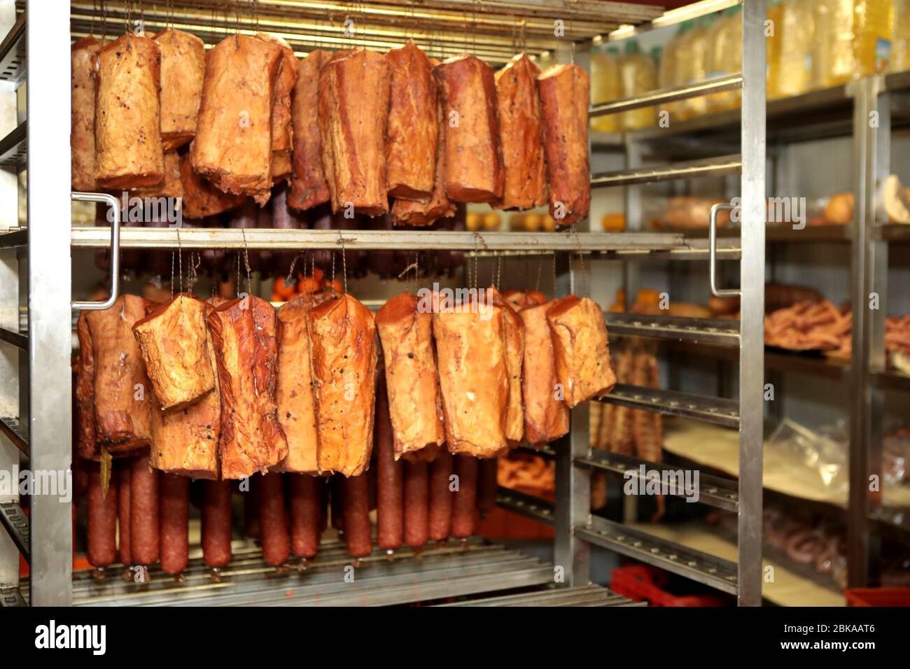 A worker at the meat processing factory, prepares sausages at the work ...