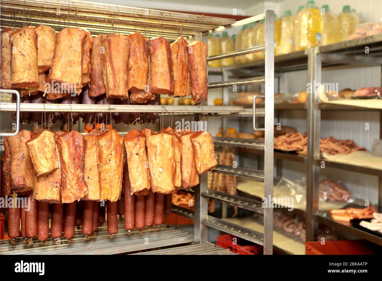 A worker at the meat processing factory, prepares sausages at the work ...