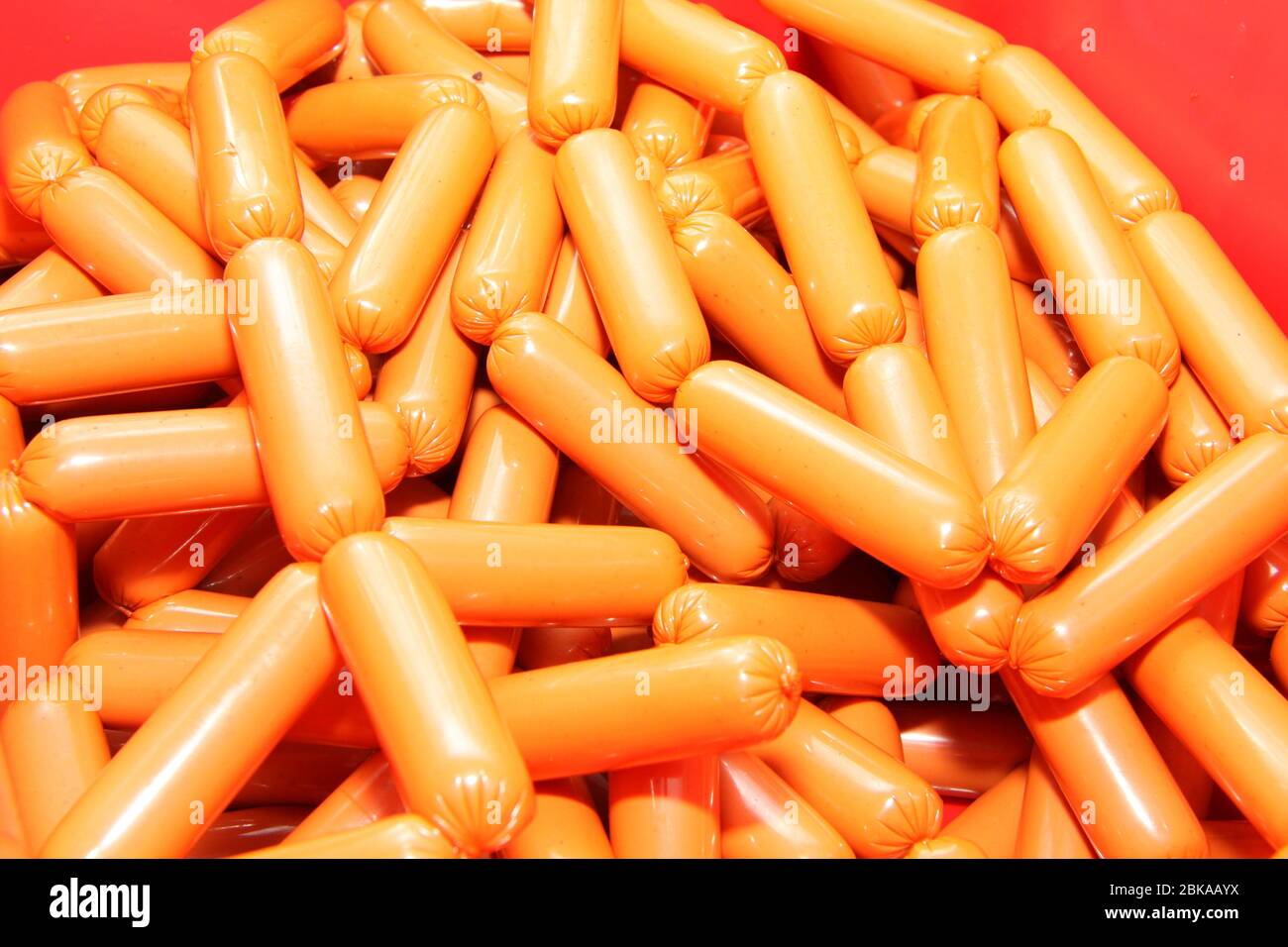 A worker at the meat processing factory, prepares sausages at the work ...