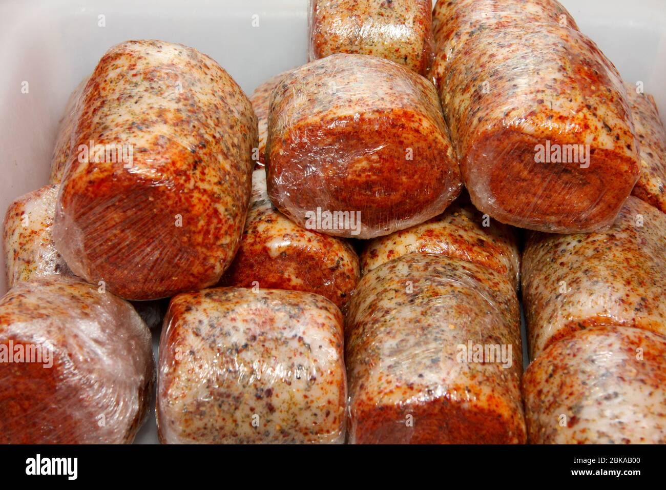 A worker at the meat processing factory, prepares sausages at the work ...