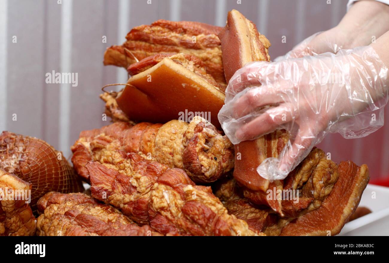 A worker at the meat processing factory, prepares sausages at the work ...