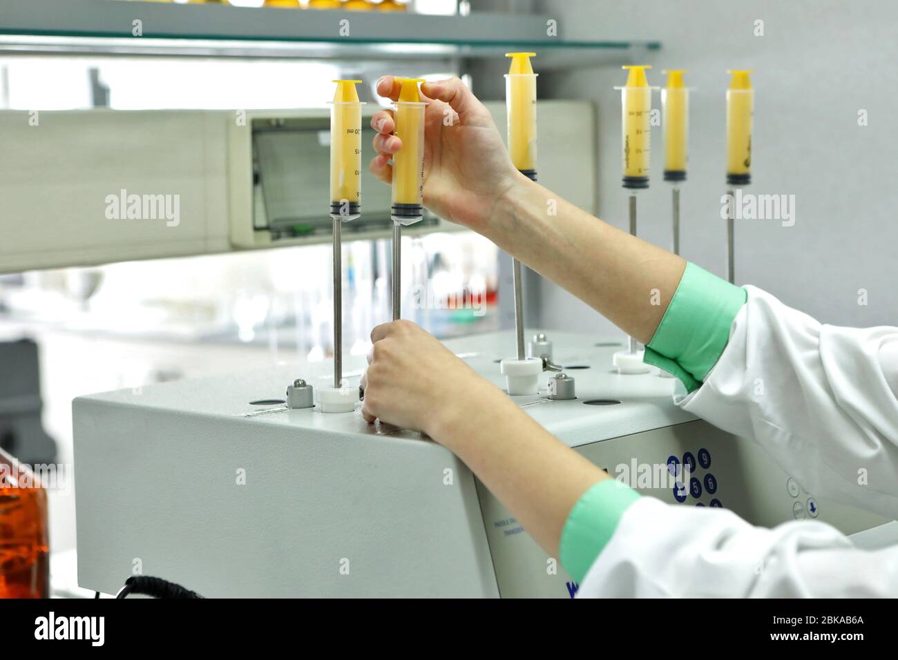 A female chemist conducts solubility tests of tablets and other dosage ...