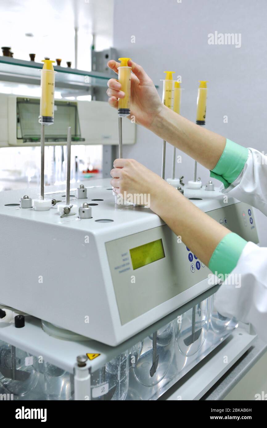 A female chemist conducts solubility tests of tablets and other dosage ...