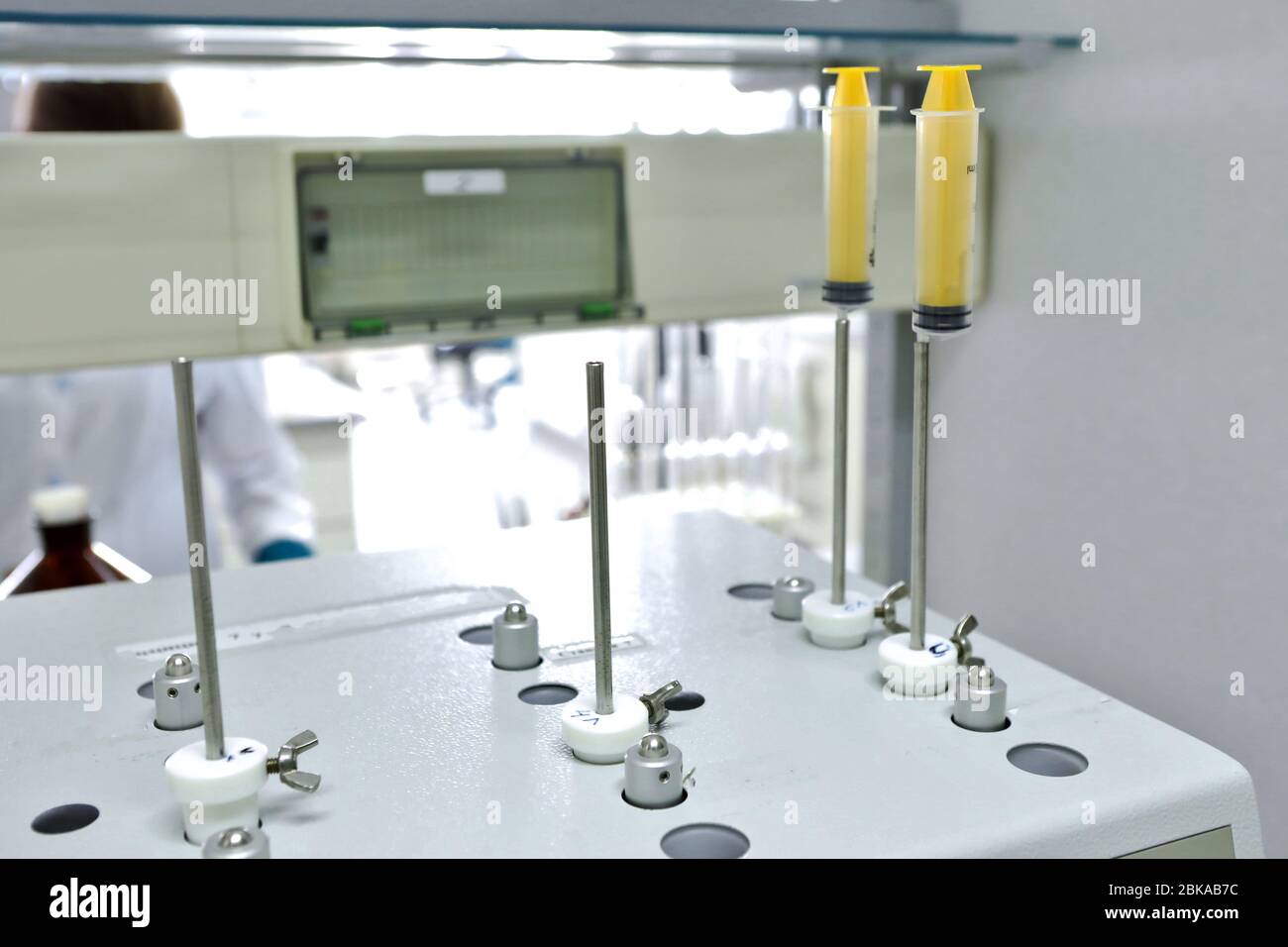 A female chemist conducts solubility tests of tablets and other dosage ...