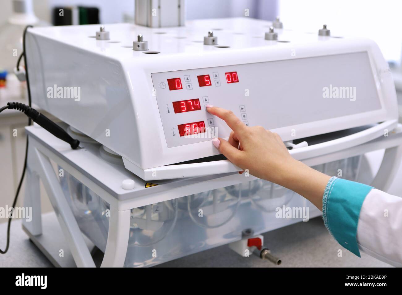A female chemist conducts solubility tests of tablets and other dosage ...