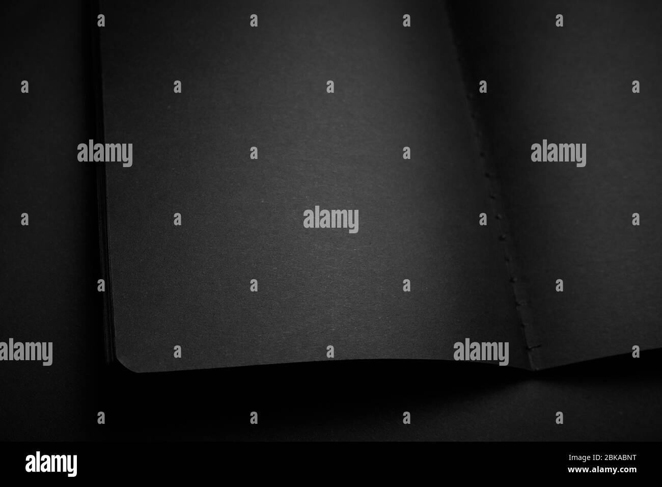 Blank black notebook on a black table, mockup photo. Blank black cover ...