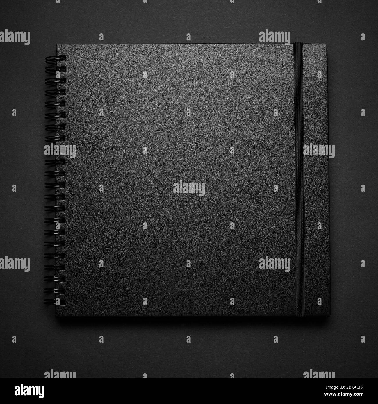Blank black notebook on a black table, mockup photo. Blank black cover ...