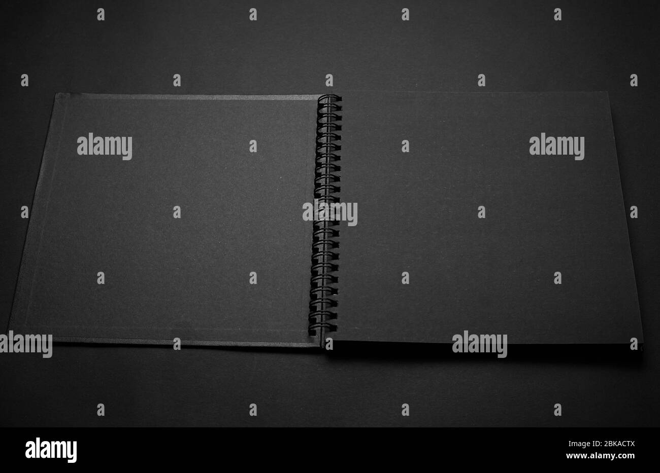 Blank black notebook on a black table, mockup photo. Blank black cover ...
