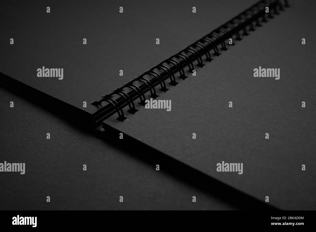 Blank black notebook on a black table, mockup photo. Blank black cover ...