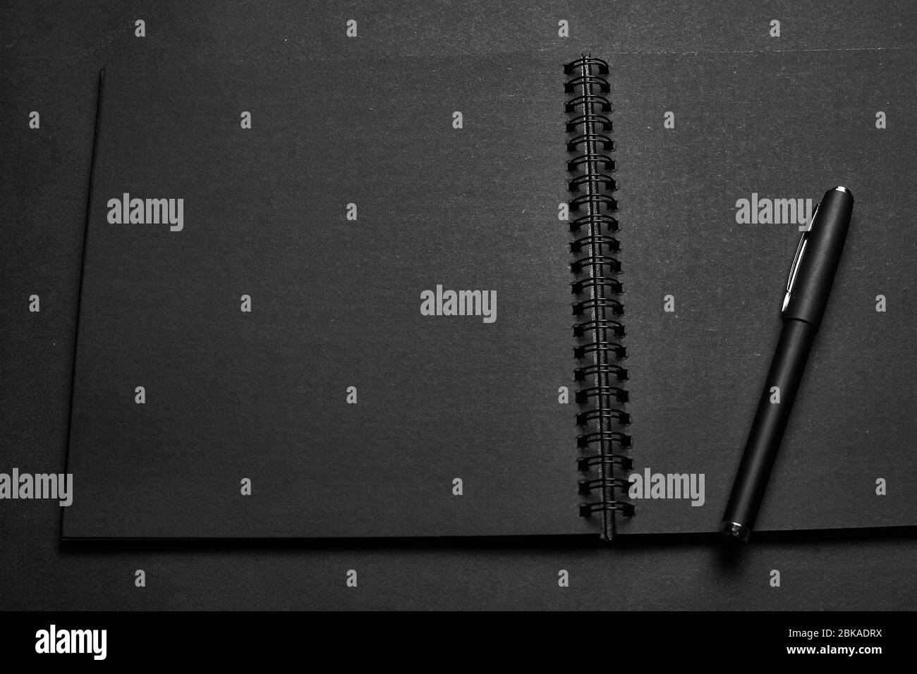 Blank black notebook on a black table, mockup photo. Blank black cover ...