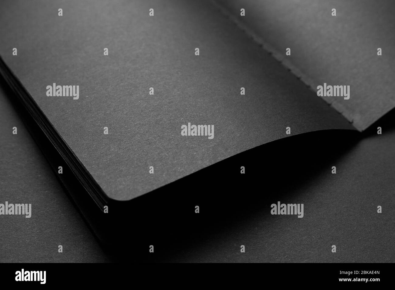 Blank black notebook on a black table, mockup photo. Blank black cover ...