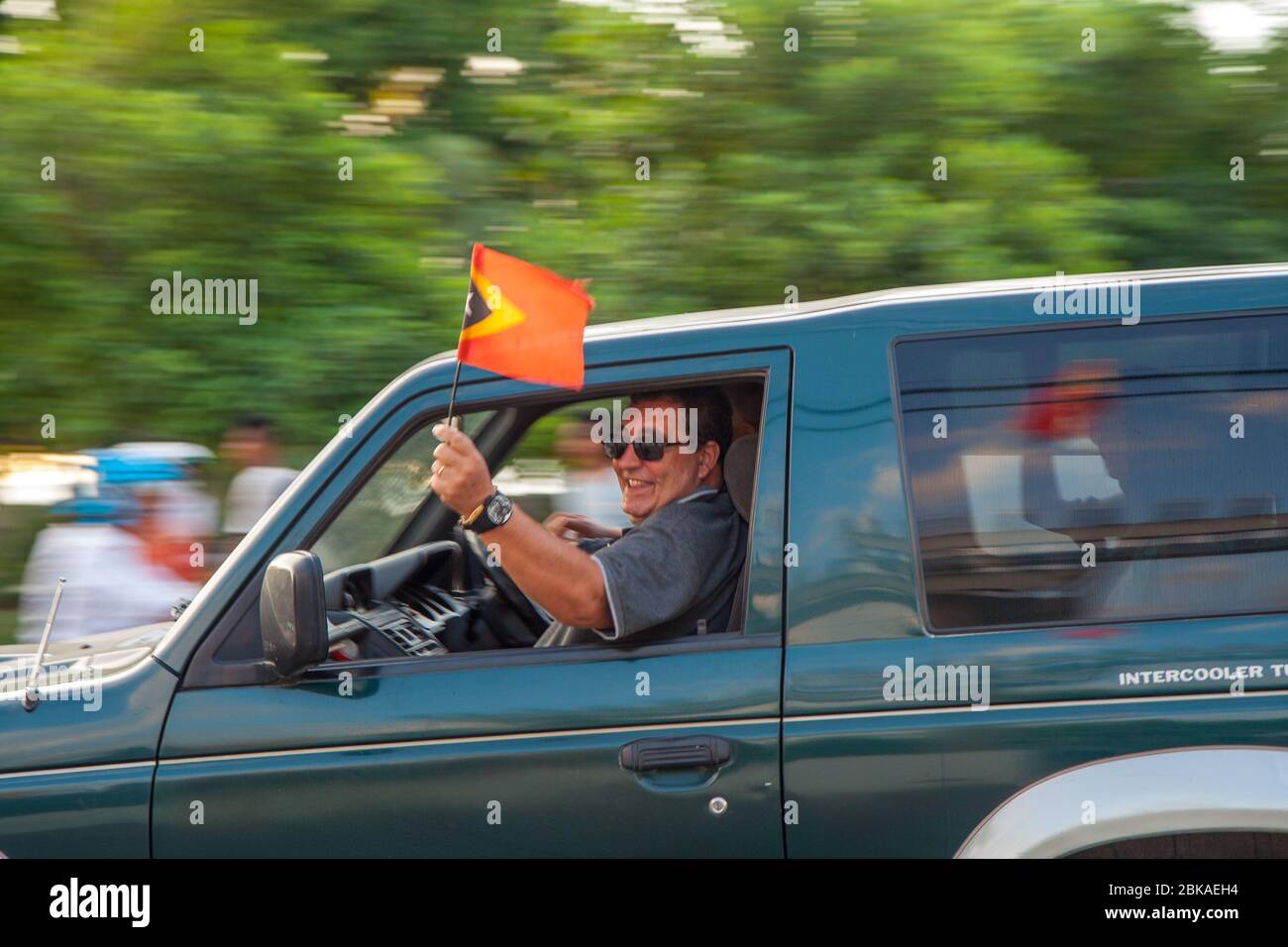 Dili, Timor-Leste. 20th May 2016. A man waves the Timorese flag from a ...