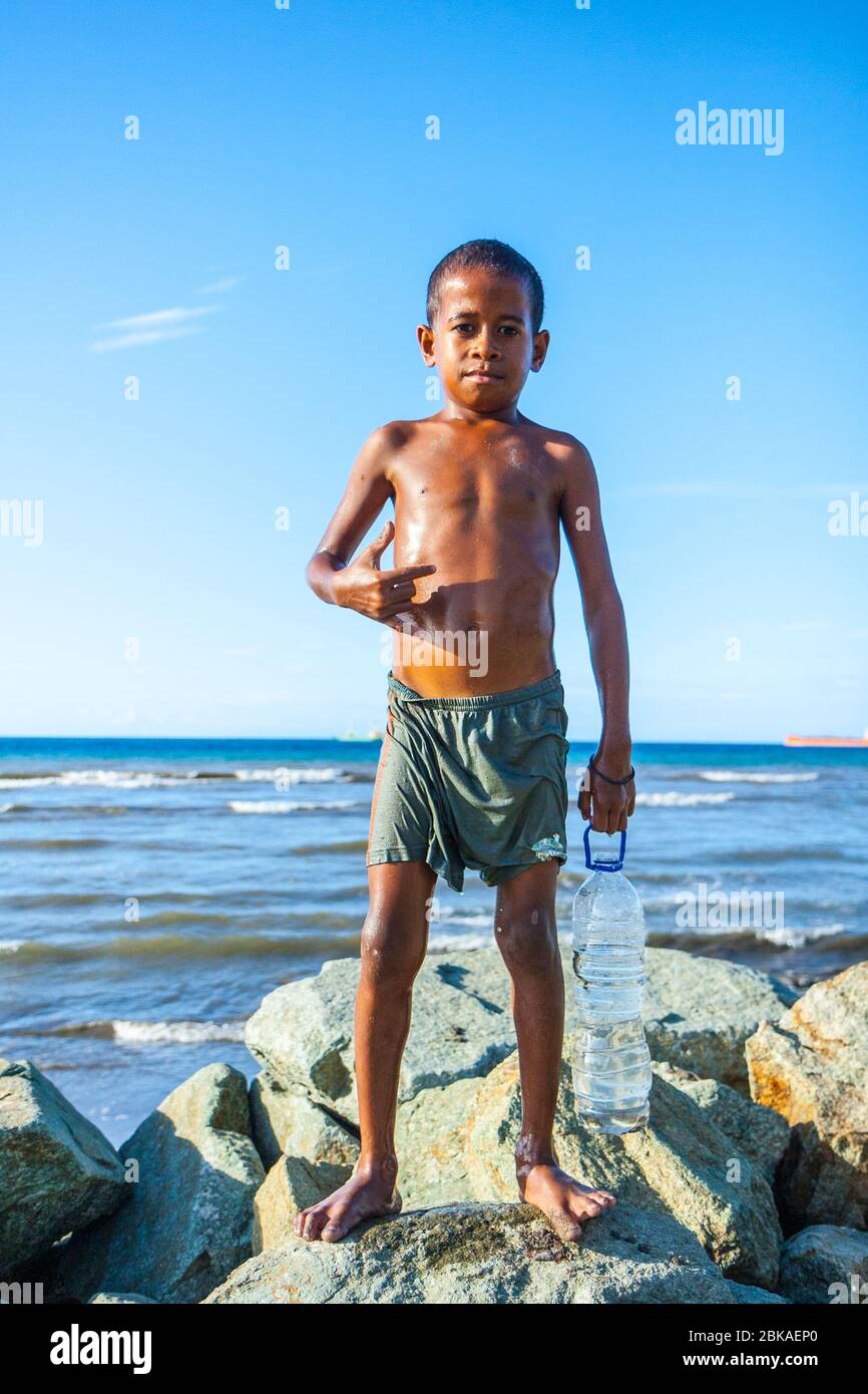 A small child wearing just underpants stands by the waterfront in Dili ...