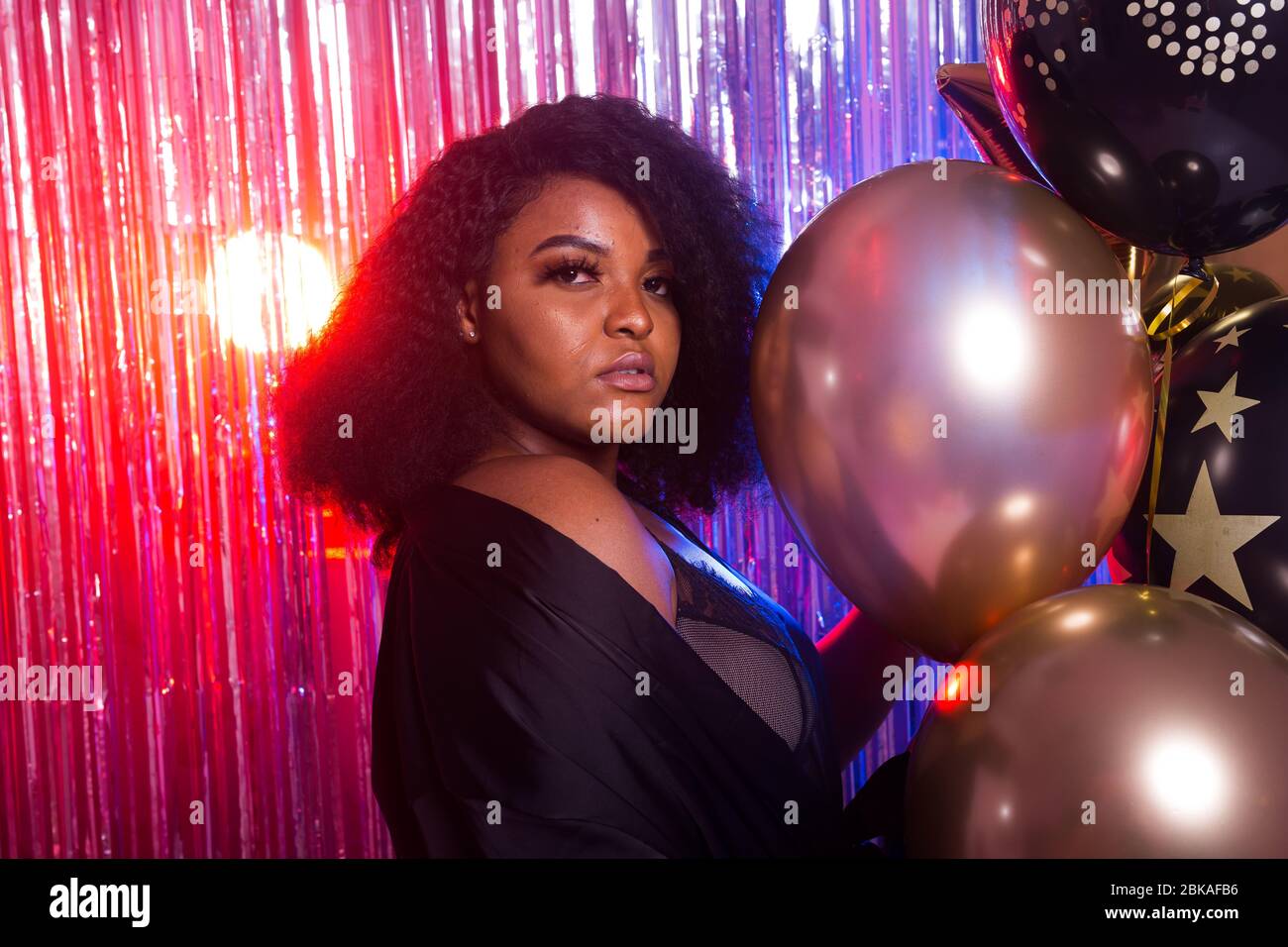 Young black woman looks happy while spend time in night club. Birthday ...