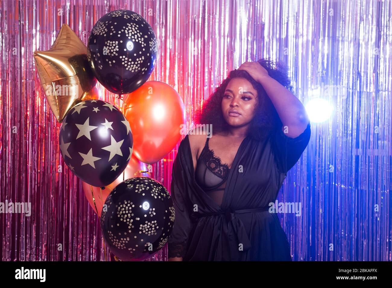 Young black woman looks happy while spend time in night club. Birthday ...
