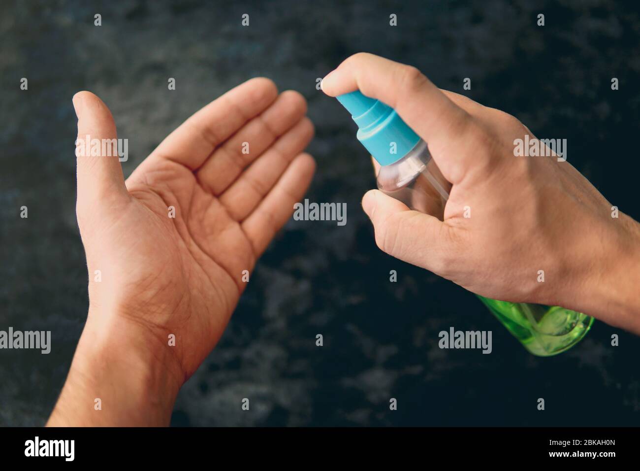 Applying alcohol sanitizer spray or antibacterial spray at arm to ...