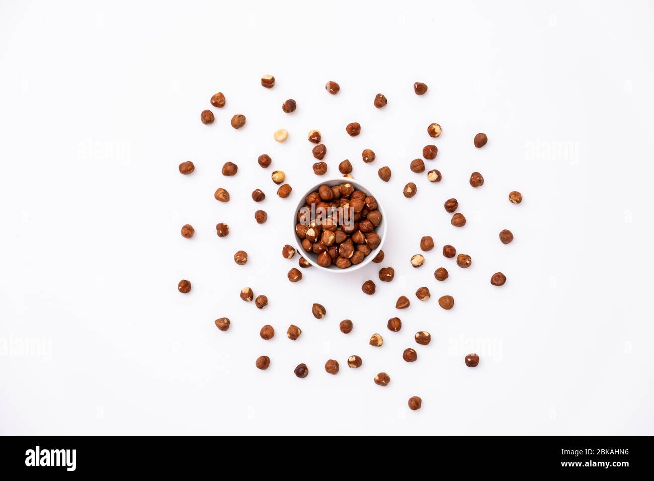 Raw hazelnuts in a bowl and around on white background. Isolated ...