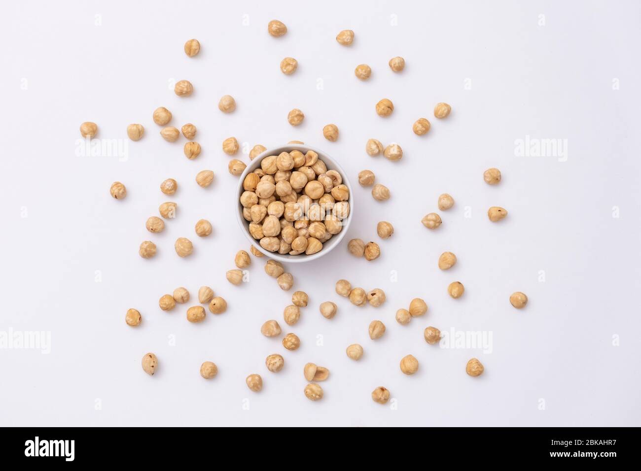Raw hazelnuts in a bowl and around on white background. Isolated ...