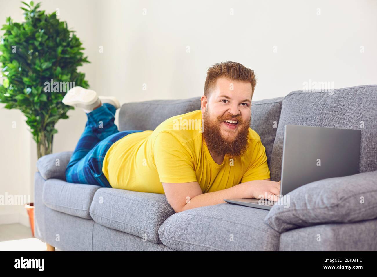 Funny fat man working online shopping shrpping watching a video at home ...