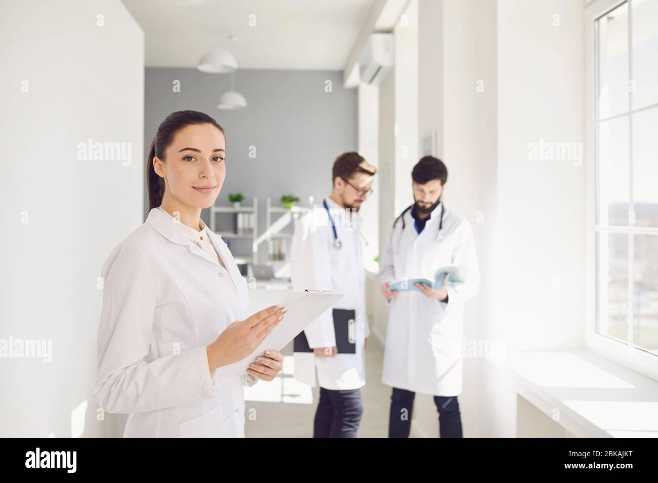 A practicing woman doctor with a stethoscope smiles against the ...