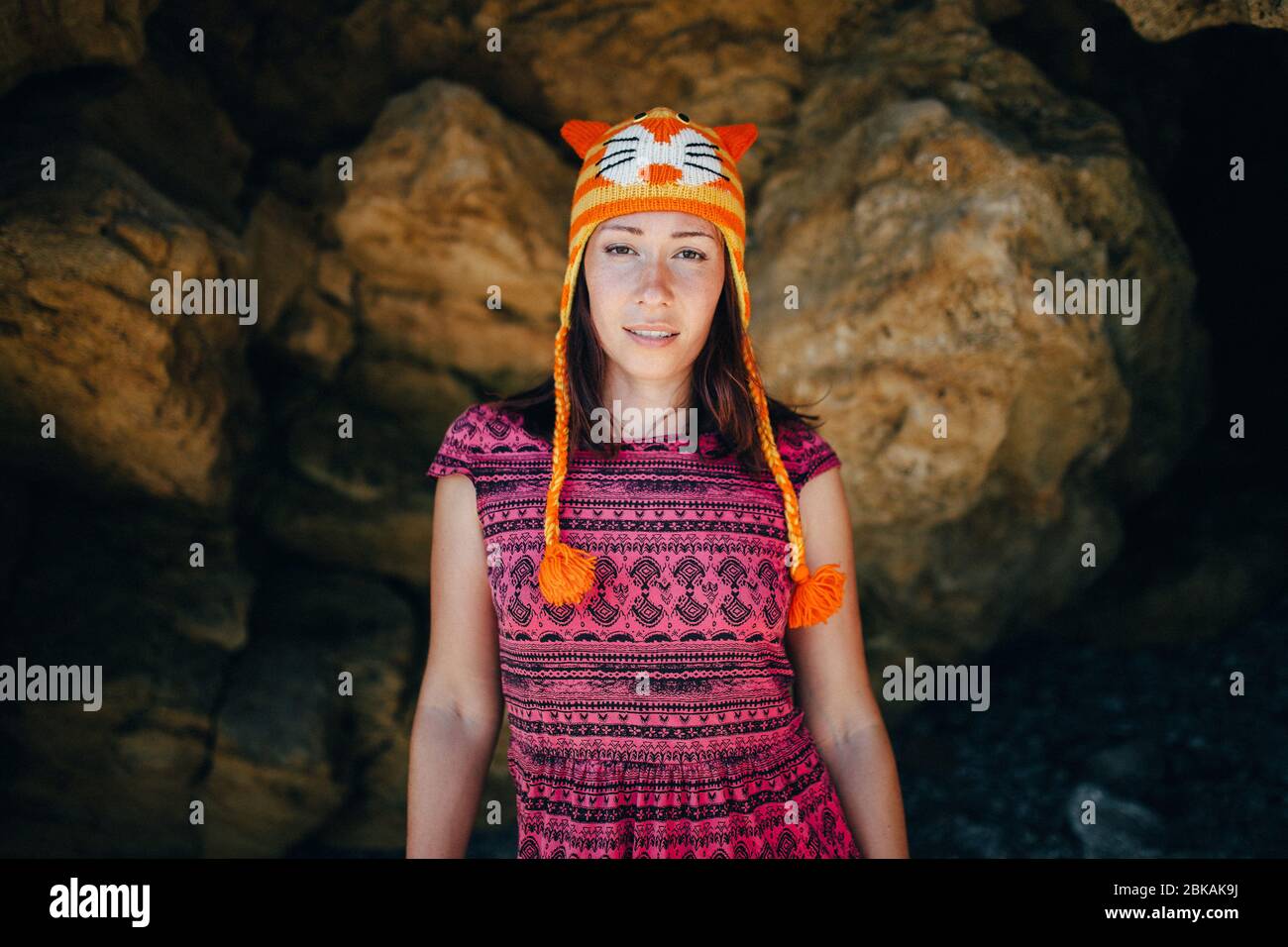 girl with different hats on a background of yellow rocks Stock Photo ...