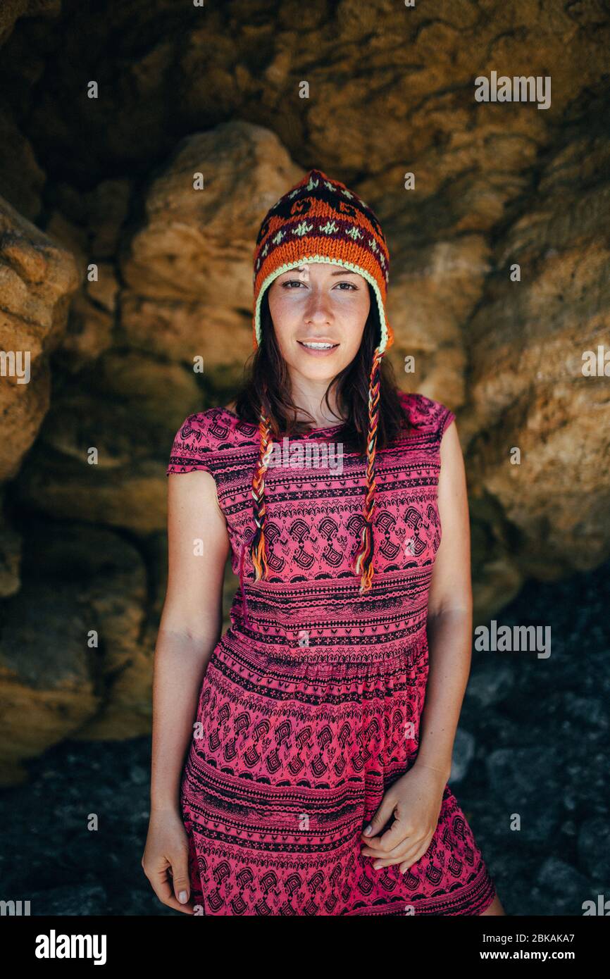 girl with different hats on a background of yellow rocks Stock Photo ...