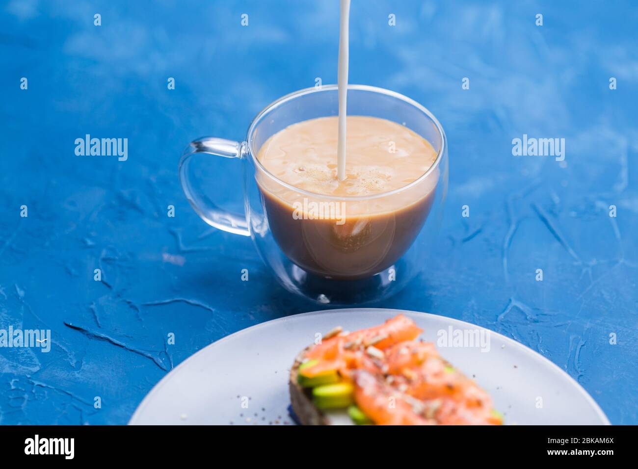 Morning and breakfast concept - Pouring cream into a cup of coffee ...
