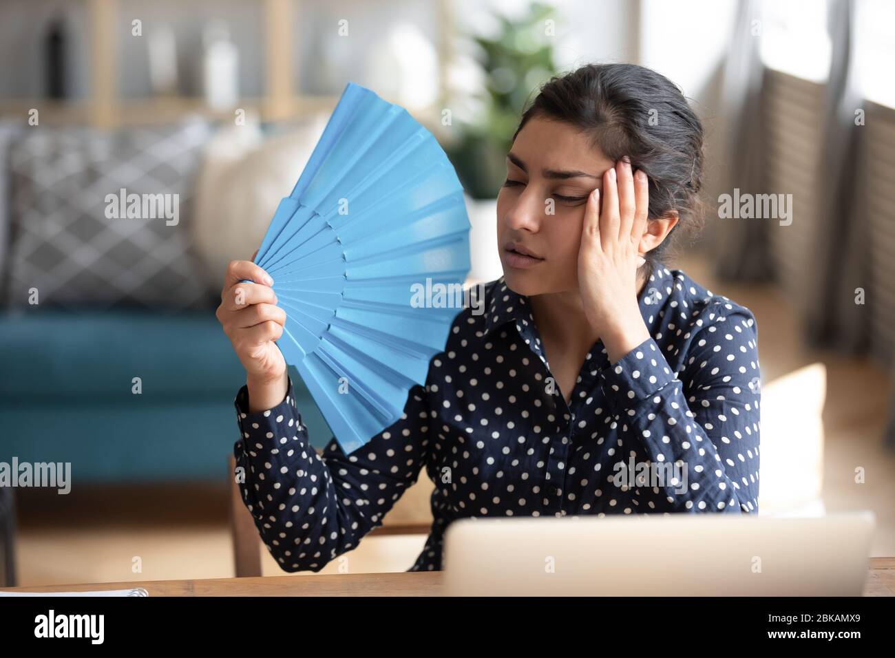 Young exhausted indian woman waving paper fan Stock Photo - Alamy