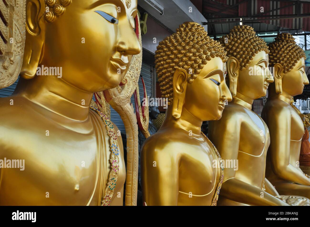 A row of golden Buddha statues placed outside a factory-cum-outlet for ...