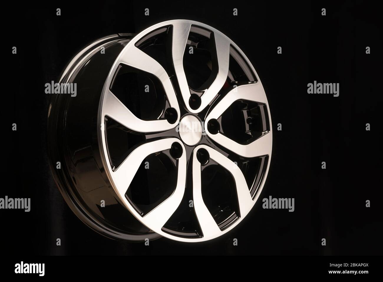 New alloy wheel of the car, close-up on a black background, wheel ...