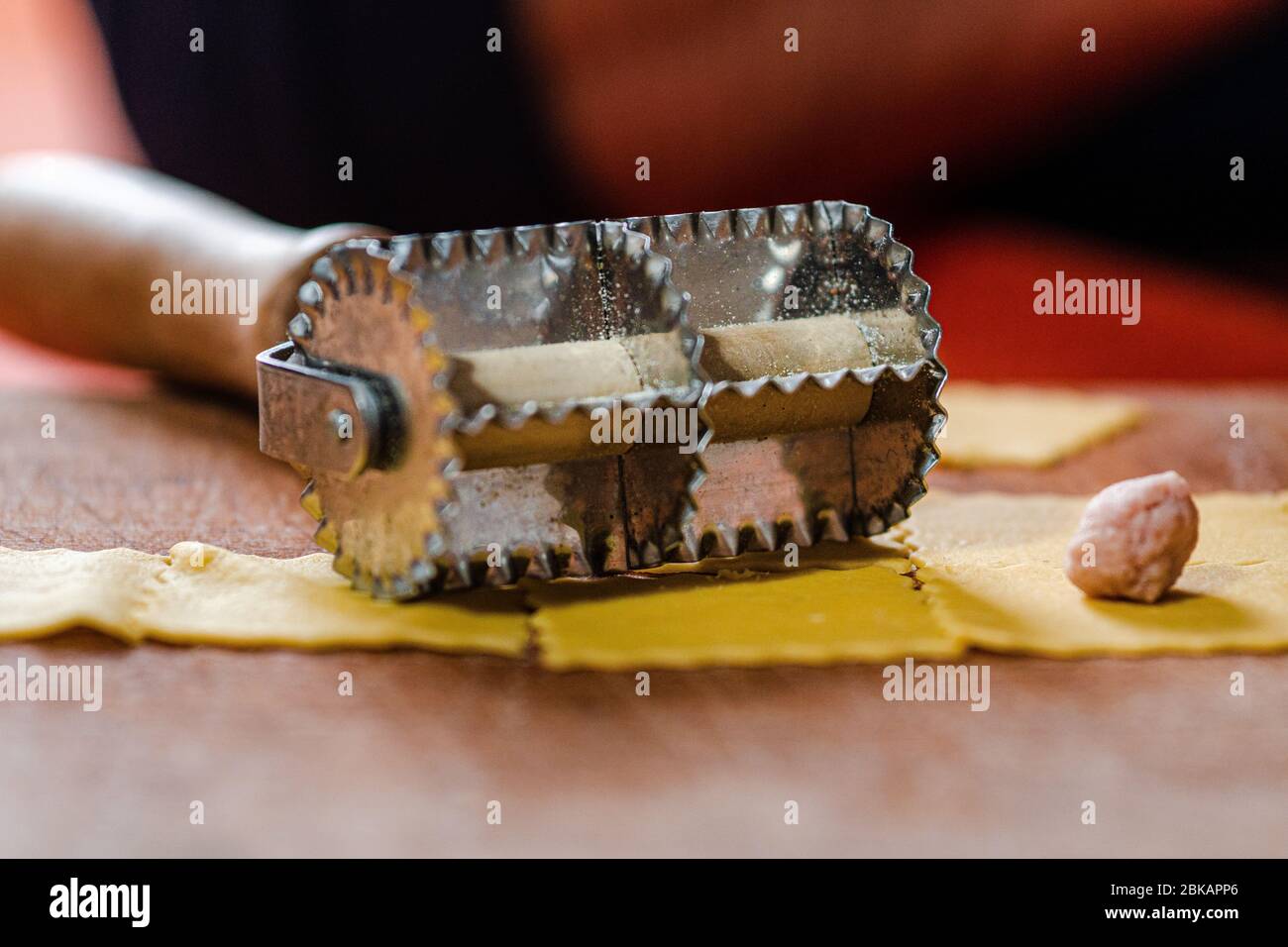 Pasta cutter is on a wooden table ready to size the fresh pasta for ...