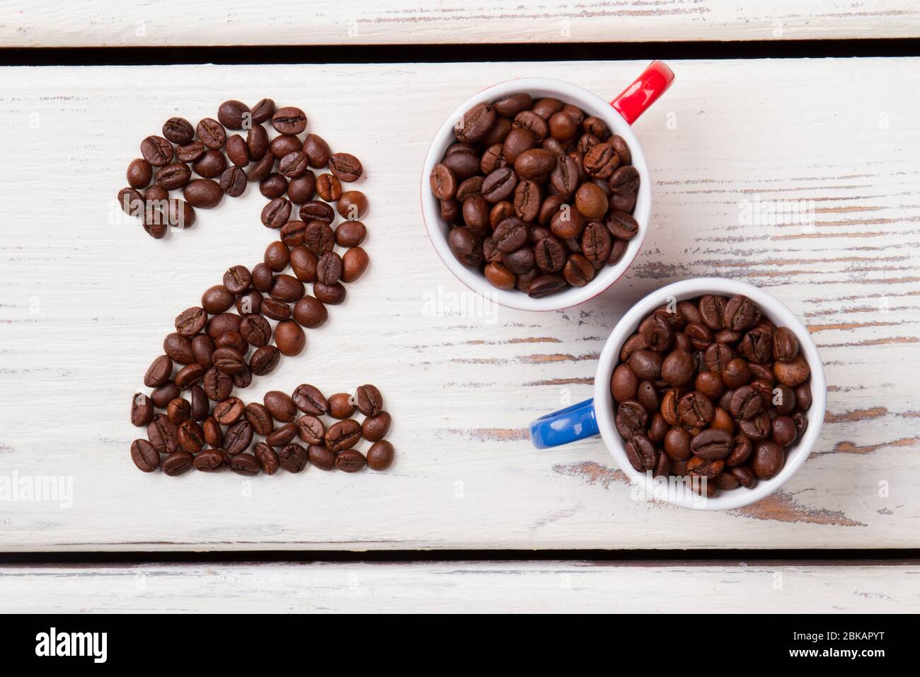Top view two cups filled with coffee beans Stock Photo - Alamy