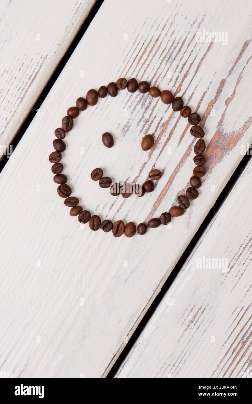 Happy smiley face made of brown coffee beans Stock Photo - Alamy