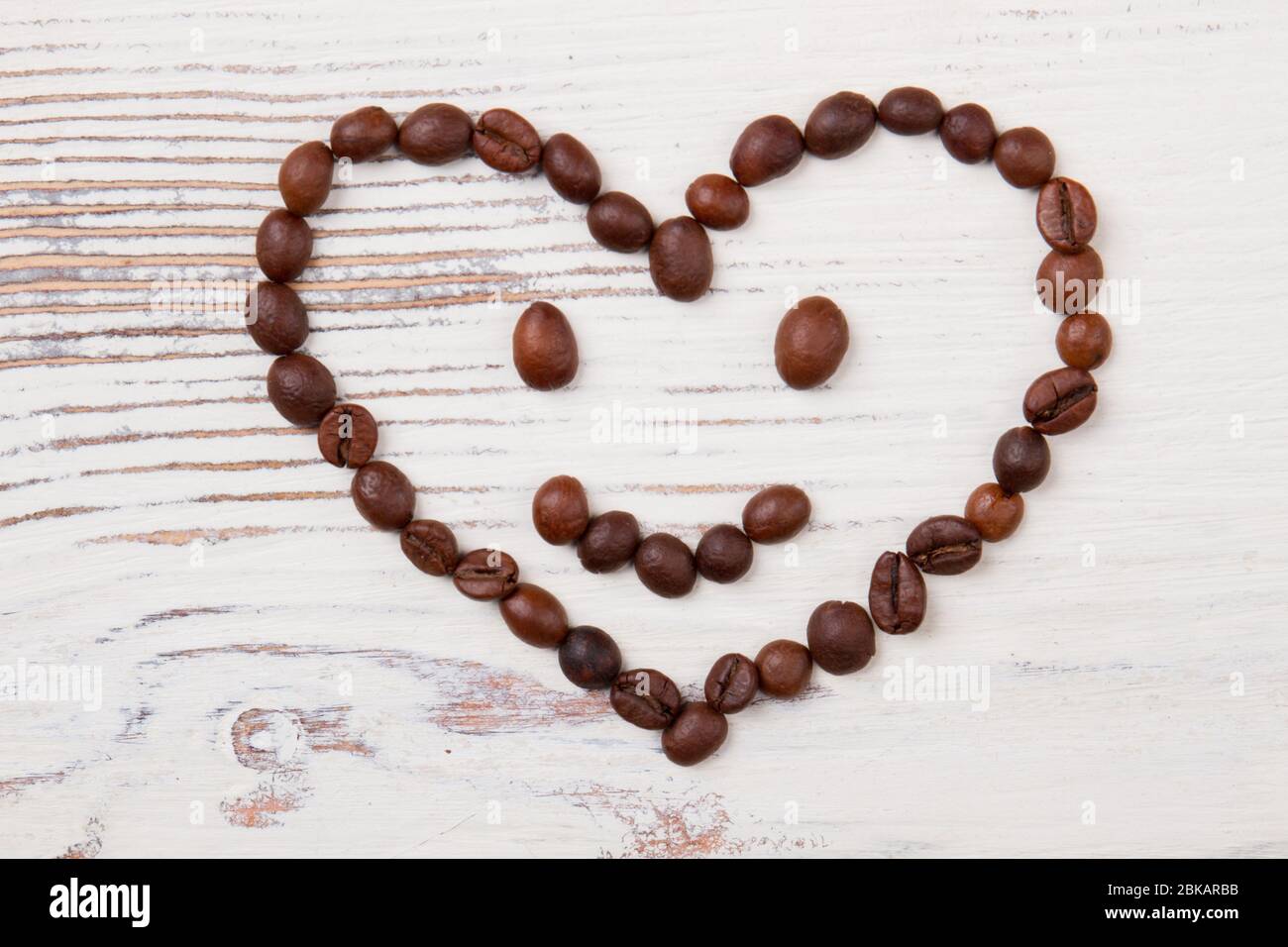 Coffee beans creating a heart shape smiling face Stock Photo - Alamy