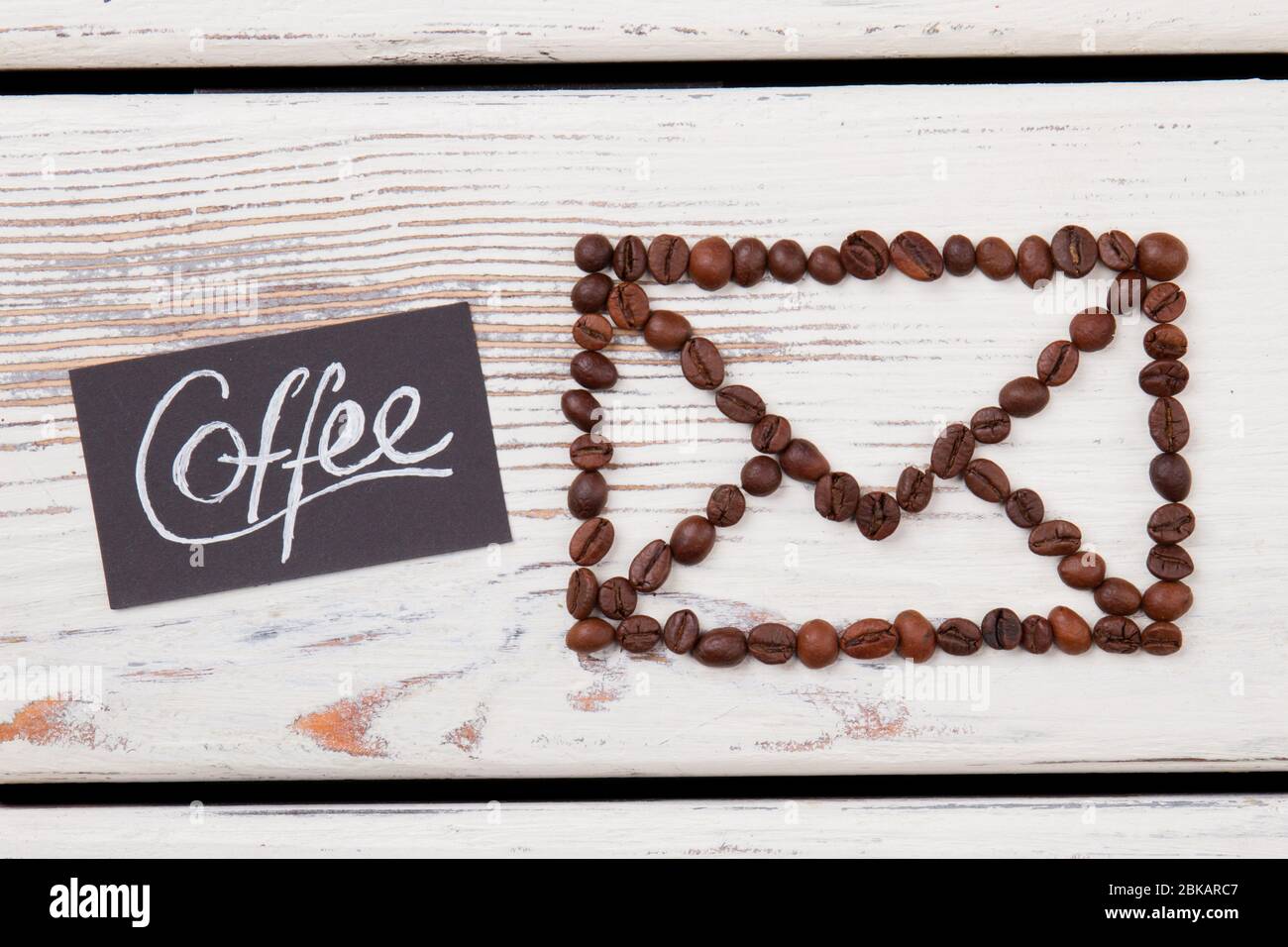 Envelope made of coffee beans on white wood Stock Photo - Alamy