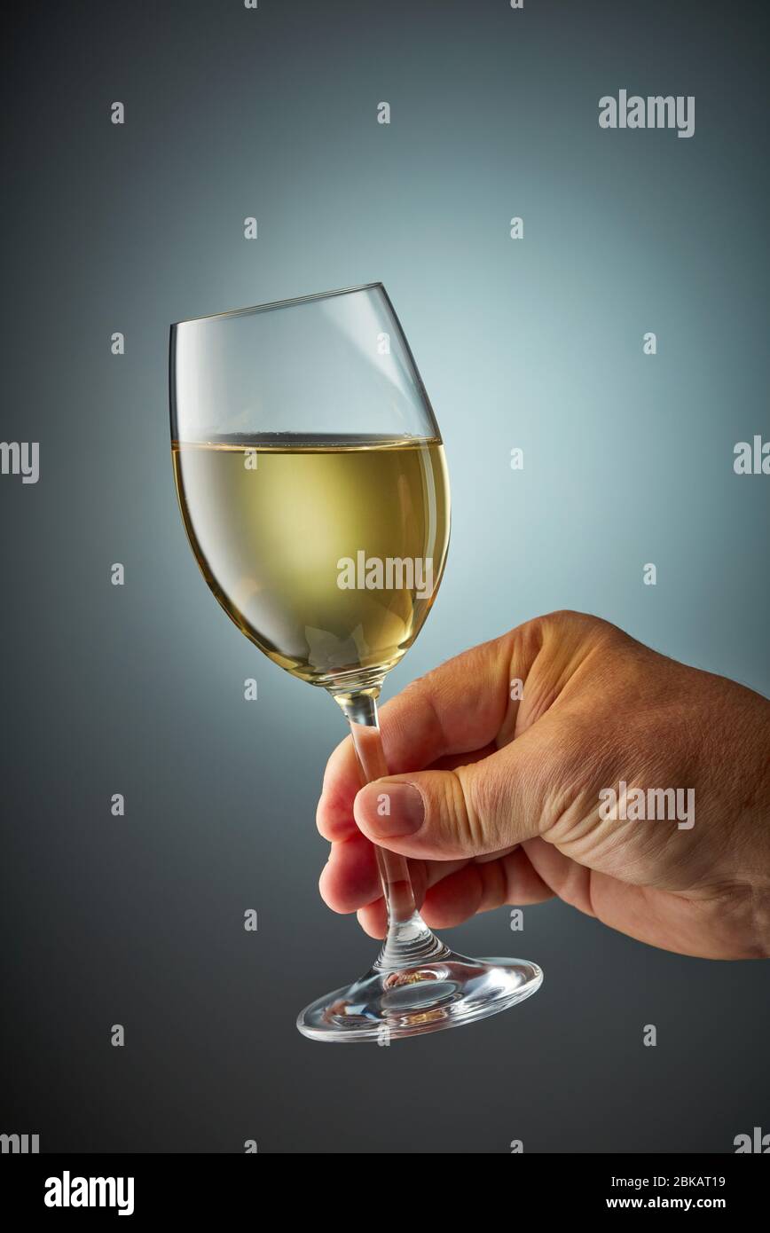 glass on white wine in human hand Stock Photo - Alamy