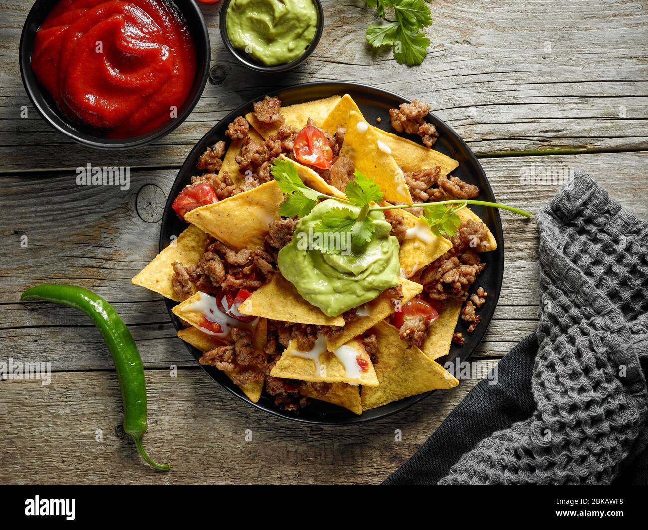 plate of corn chips nachos with fried minced meat and guacamole on ...