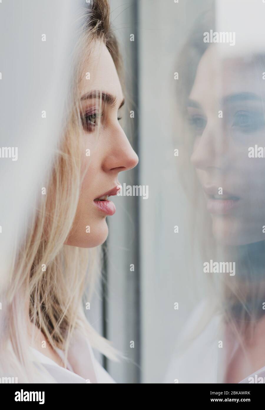 Portrait of beautiful blonde woman by the window Stock Photo - Alamy