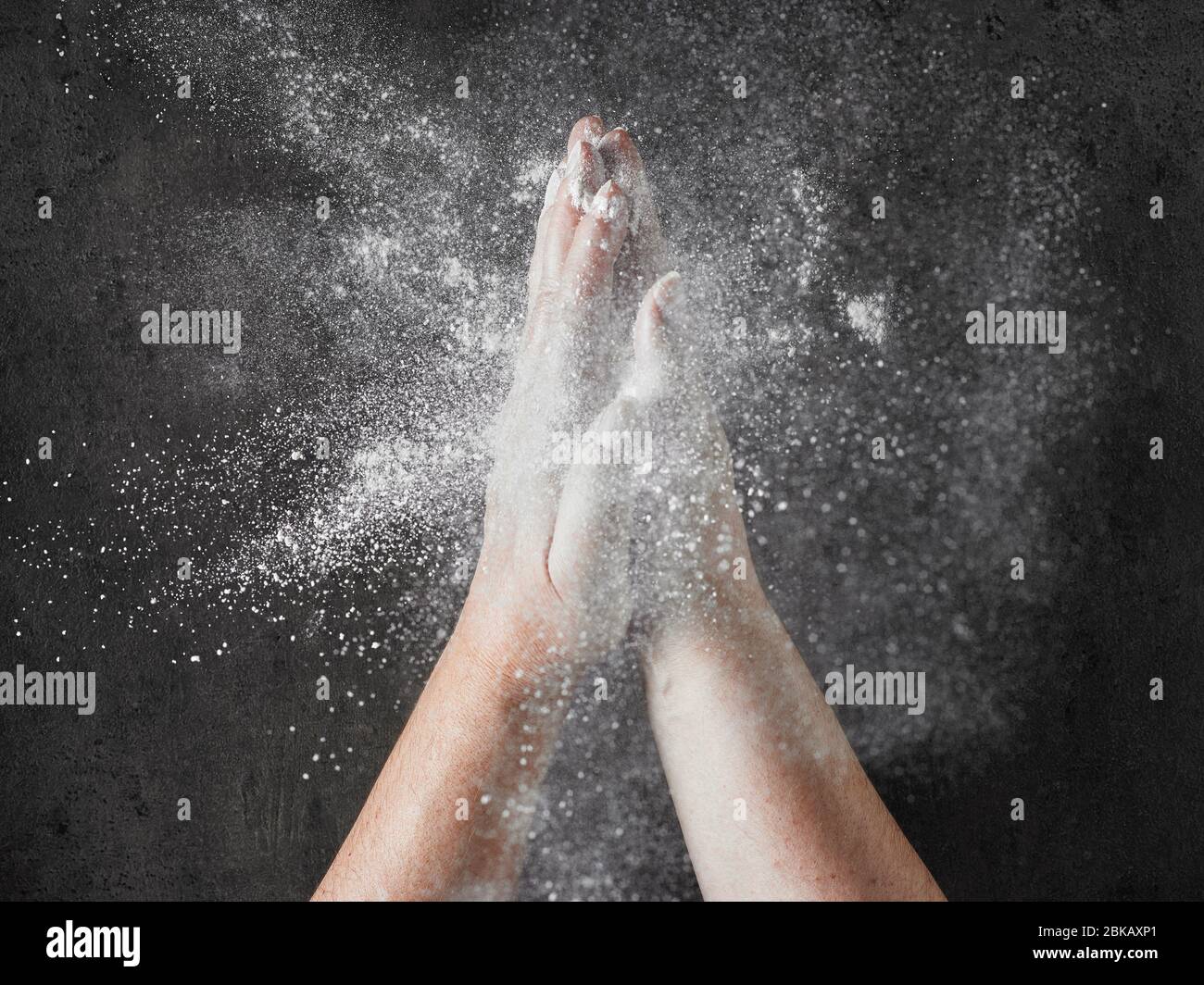baker hands with flour in motion on grey kitcen table background, top ...