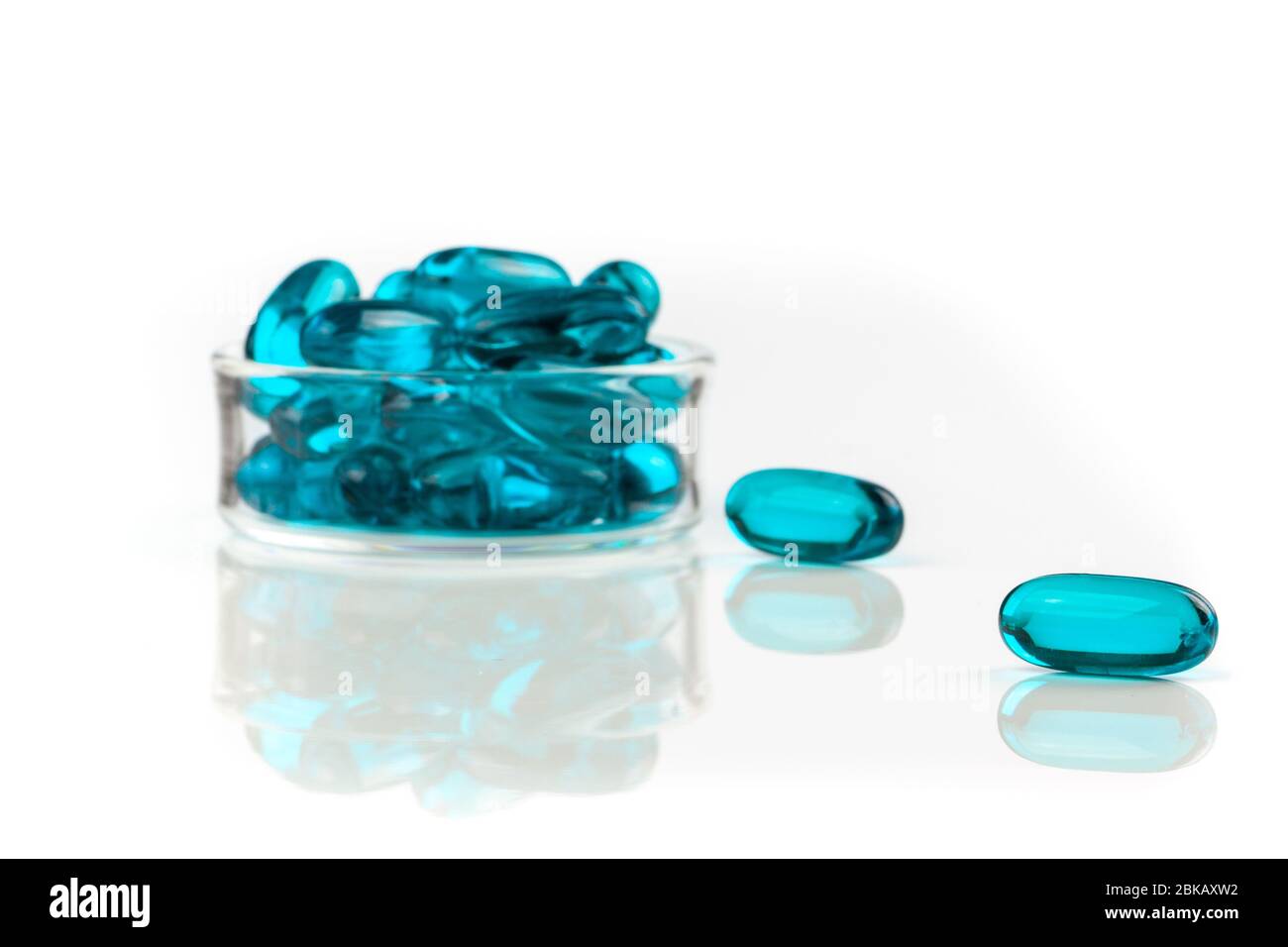 Close-up of blue medical soft gel capsules on a white background ...