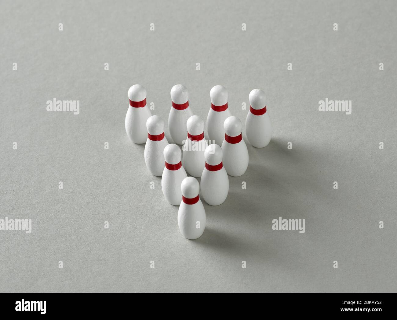 bowling pins triangle on grey paper background Stock Photo - Alamy
