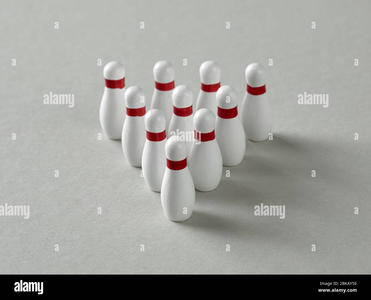 bowling pins triangle on grey paper background Stock Photo - Alamy