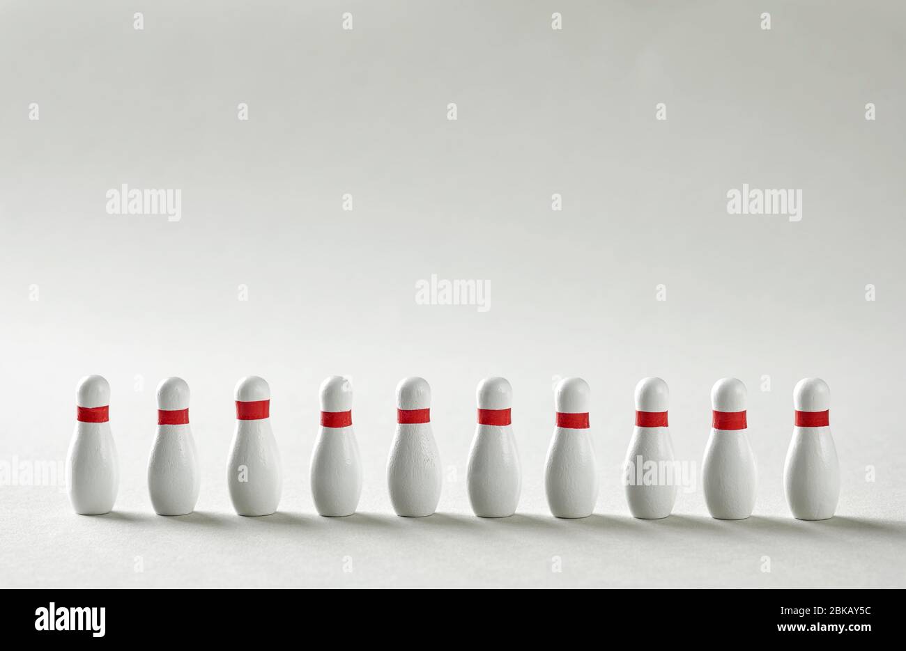 bowling pins line on grey paper background Stock Photo - Alamy