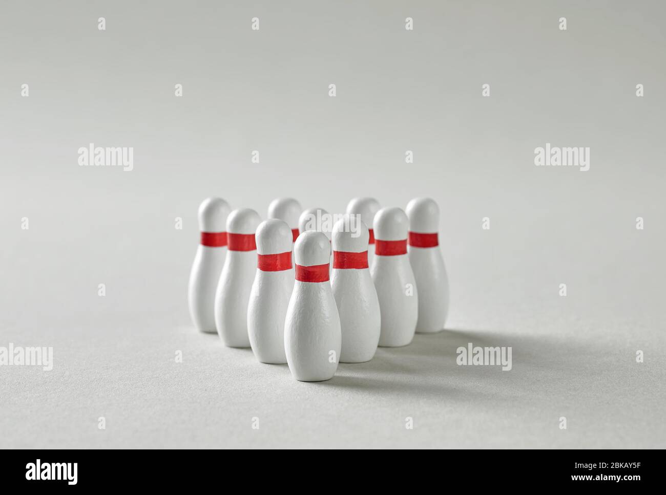 bowling pins triangle on grey paper background Stock Photo - Alamy